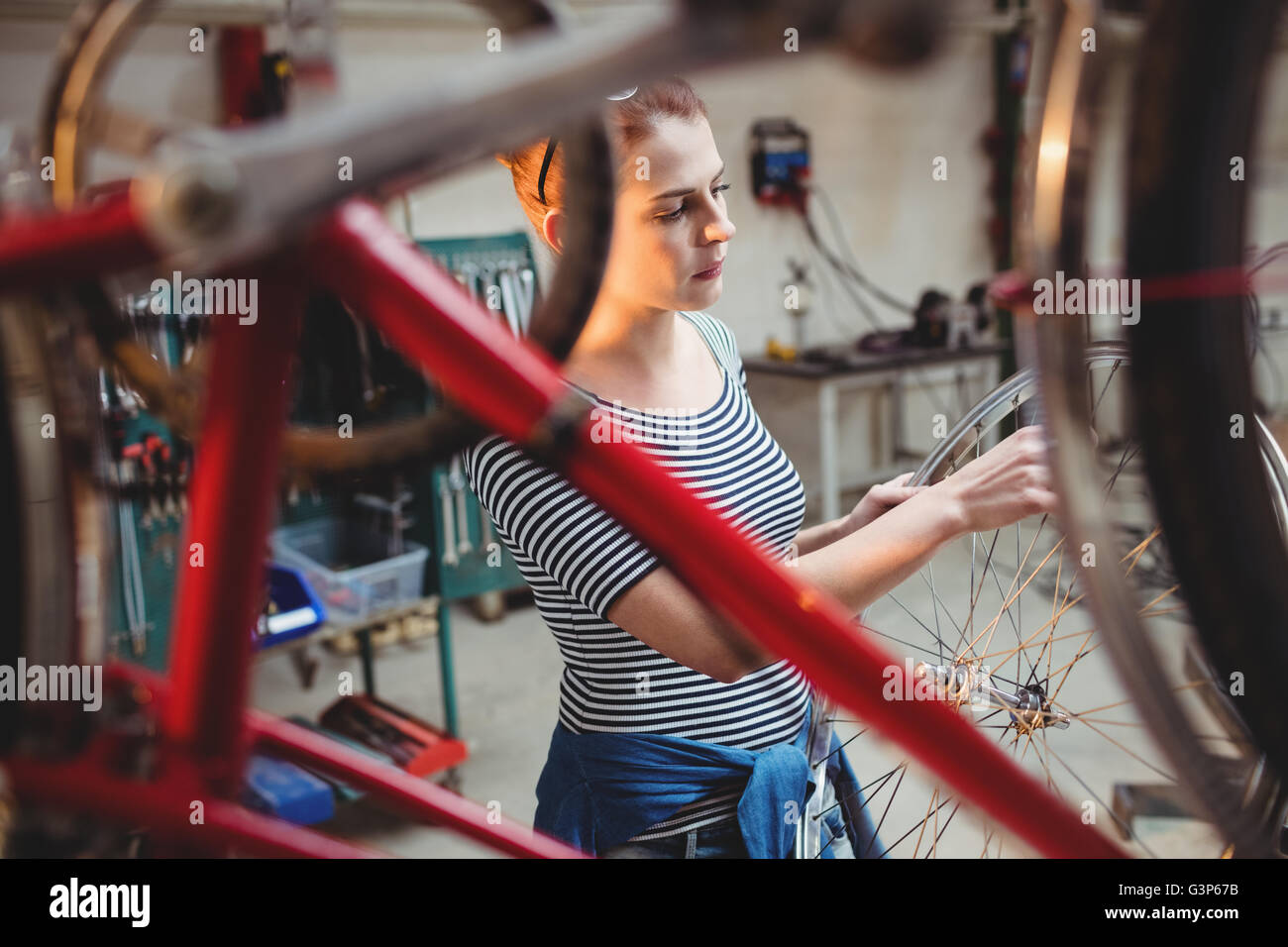 Portrait of woman repairing a wheel Stock Photo - Alamy
