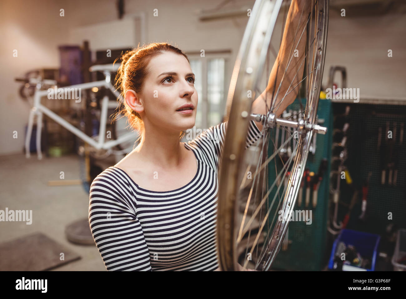 Portrait of woman fixing a bicycle in a bicycle workshop Stock Photo - Alamy
