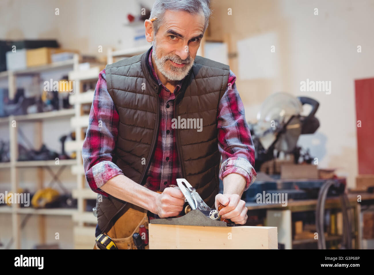Portrait of carpenter perfecting wood plank form with a work tool Stock ...