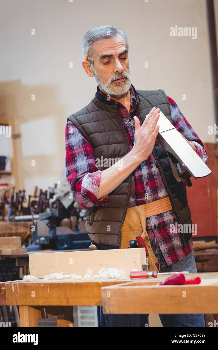 Carpenter examining a work tool Stock Photo - Alamy