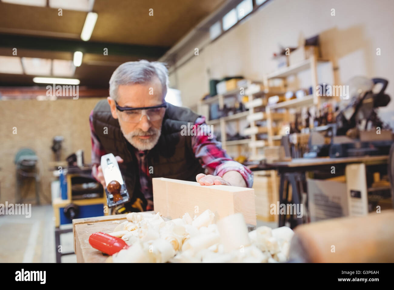 Carpenter using a sander to make smoother a wood plank Stock Photo - Alamy