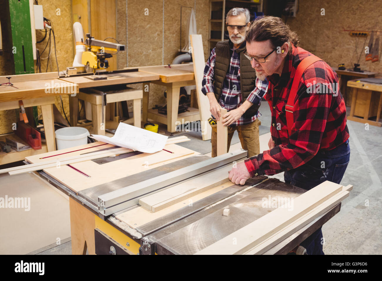 Duo of carpenter working on a wood plank Stock Photo - Alamy