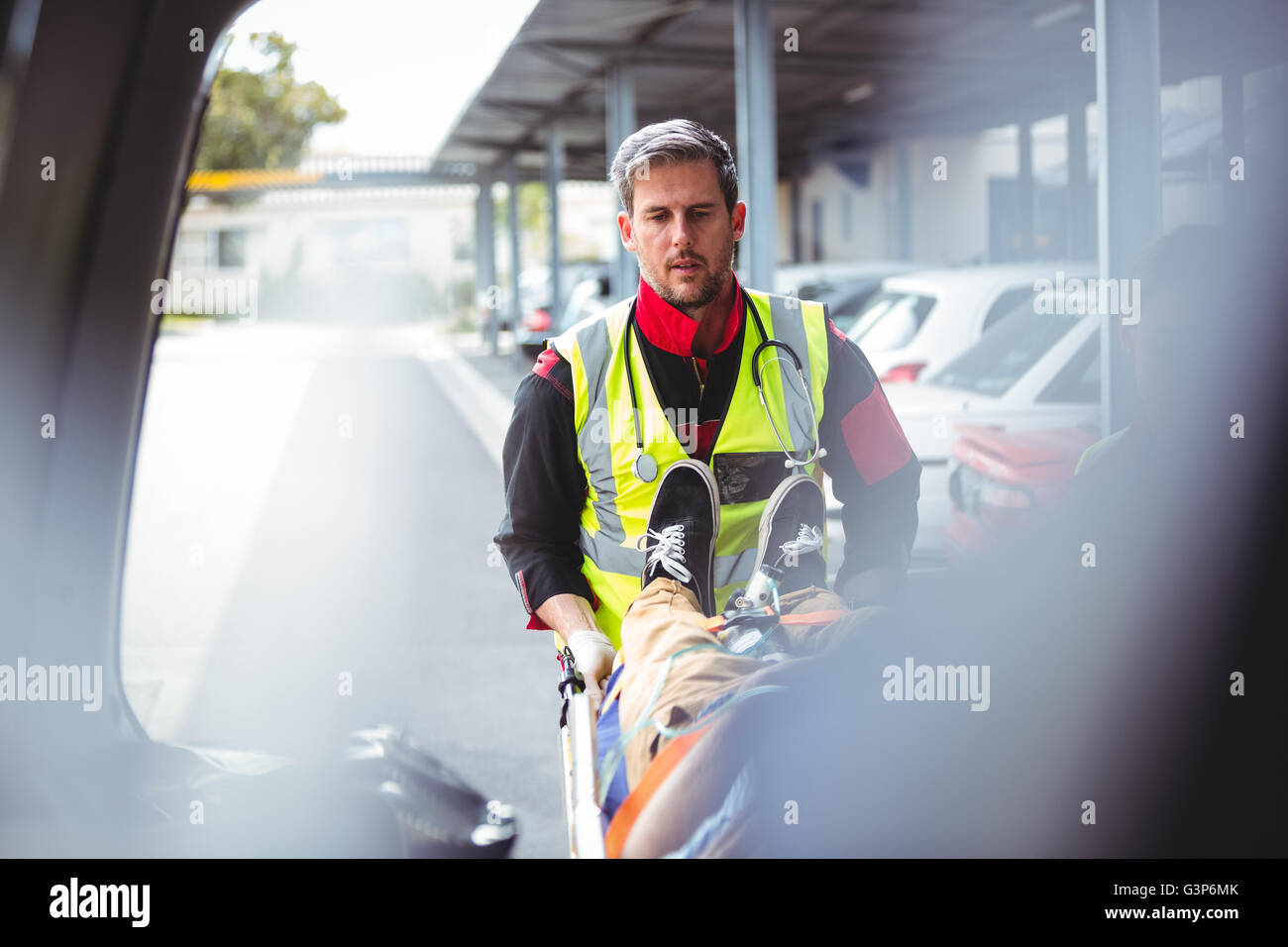Ambulance man bringing injured person inside an ambulance car Stock ...