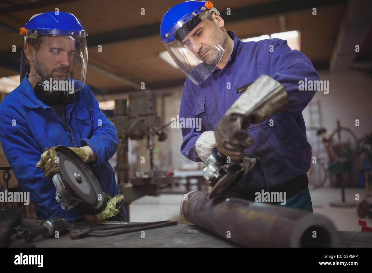 Men working together on a metal work Stock Photo - Alamy