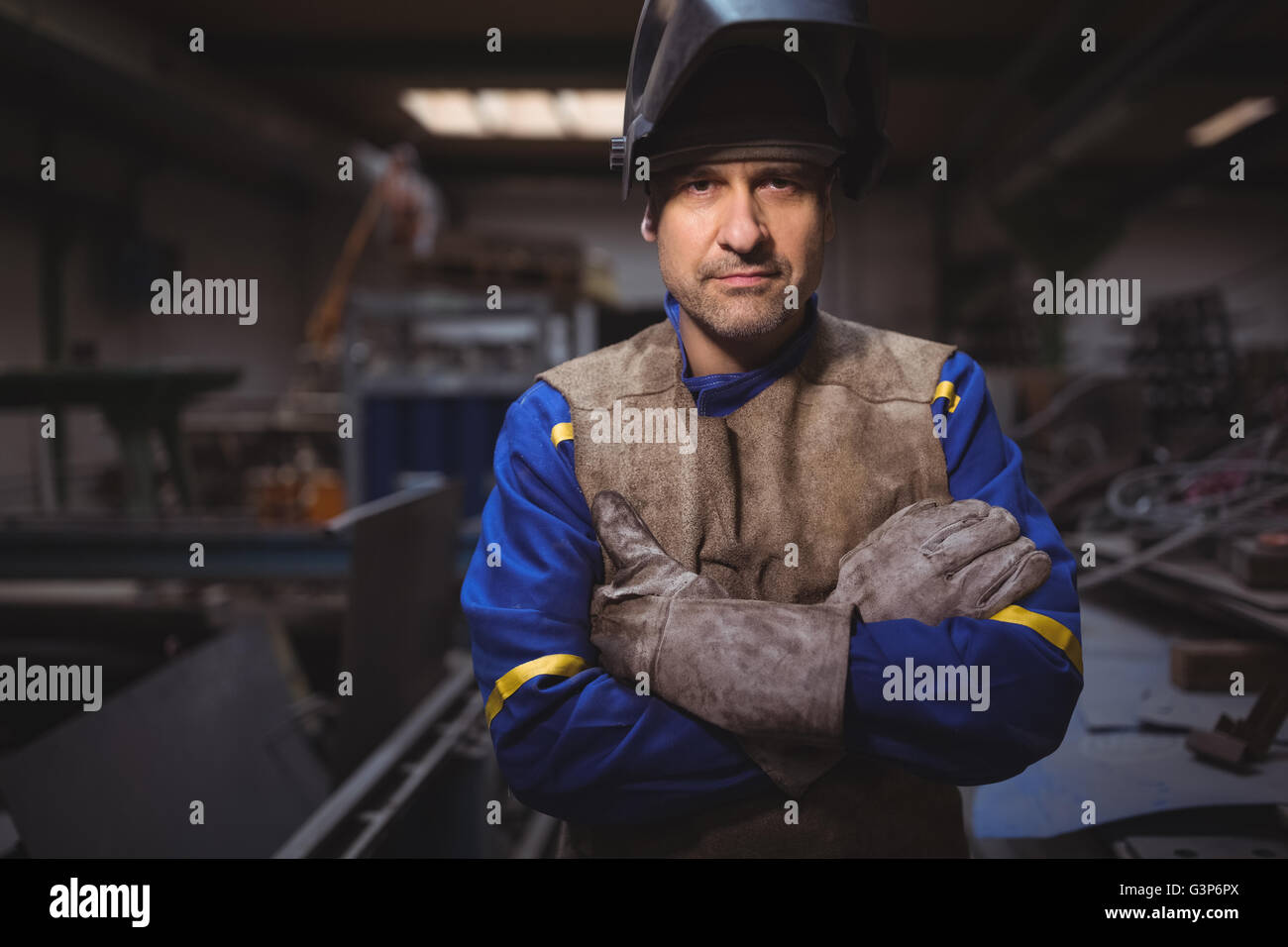 Portrait of welder standing with arms crossed in workshop Stock Photo ...