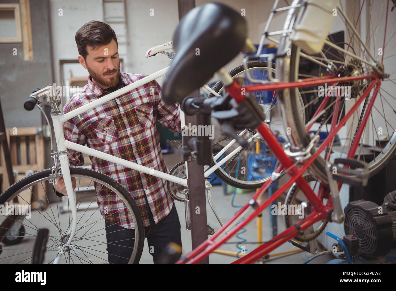 Mechanic standing repairing bicycle hi-res stock photography and images ...