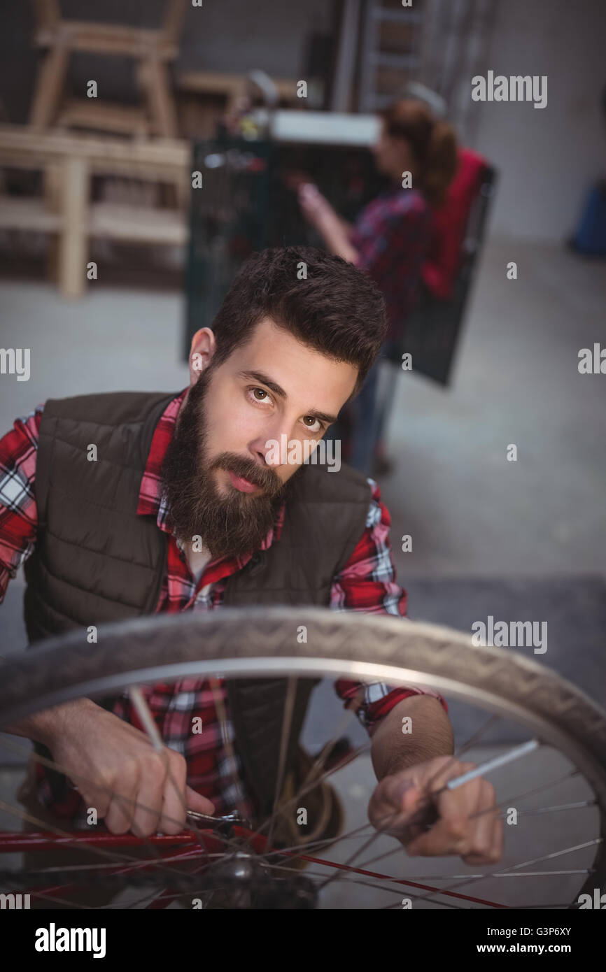 Portrait of mechanic repairing a bicycle Stock Photo - Alamy