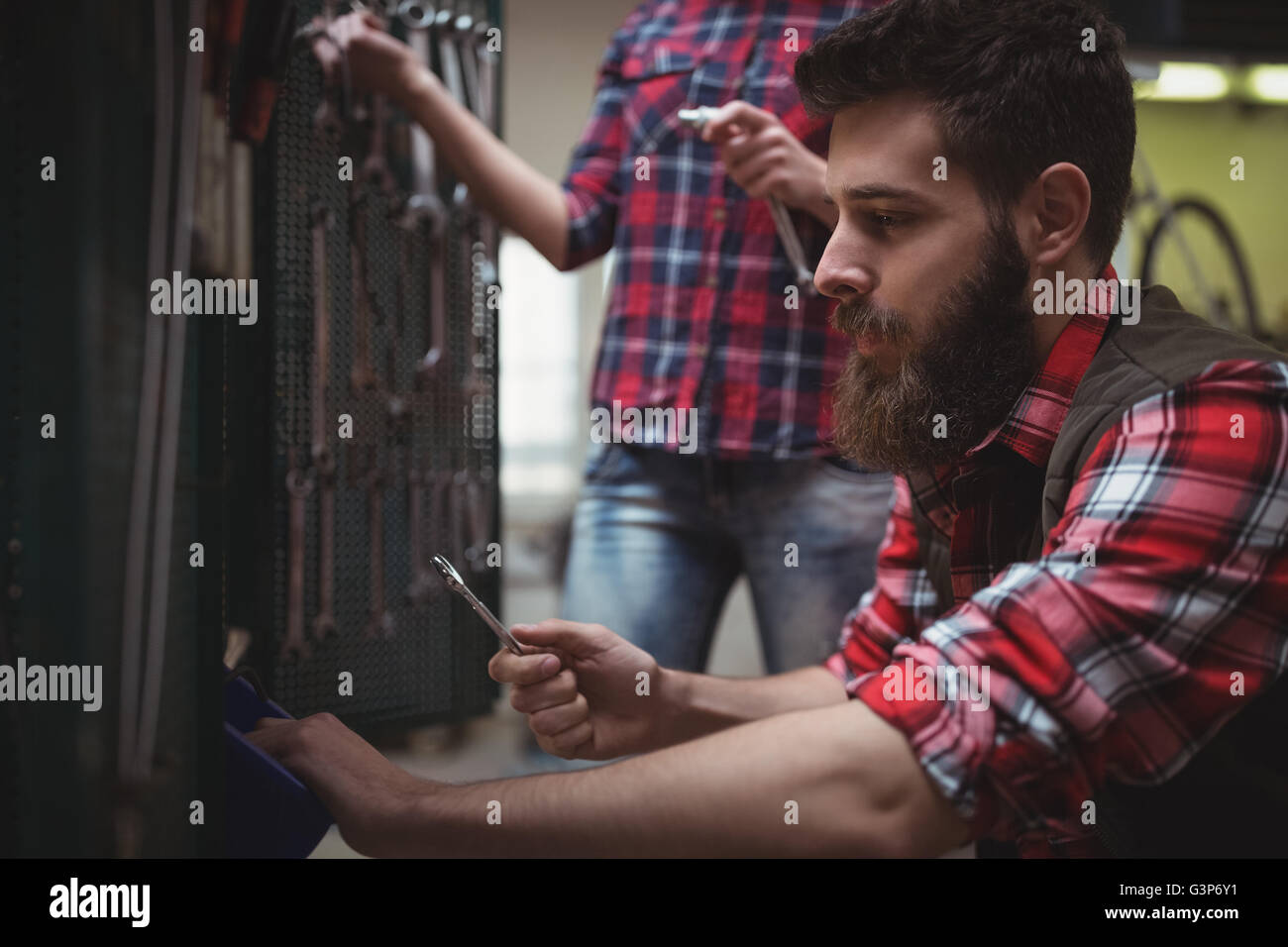 Profile view of mechanic searching a tool Stock Photo - Alamy