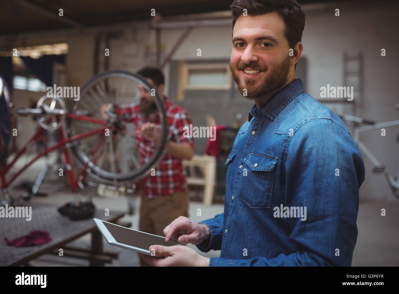 Man mechanic smiling and using a tablet computer Stock Photo - Alamy