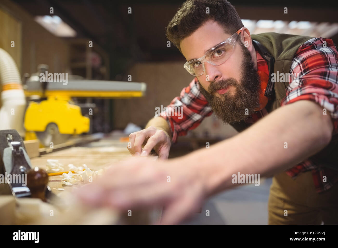 Carpenter measuring wooden plank in workshop Stock Photo - Alamy