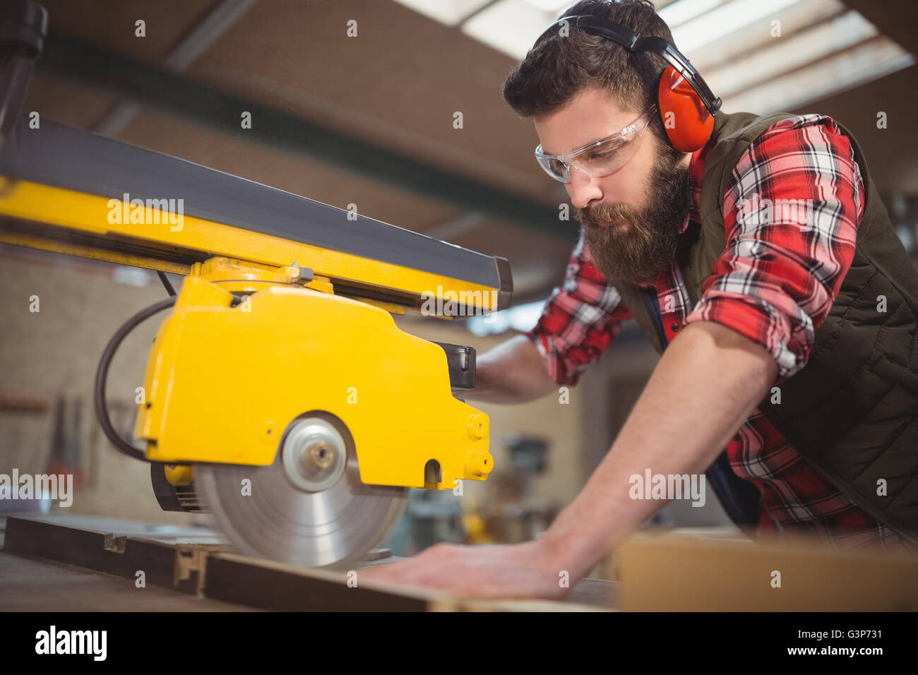 Carpenter cutting wooden plank with circular saw Stock Photo - Alamy