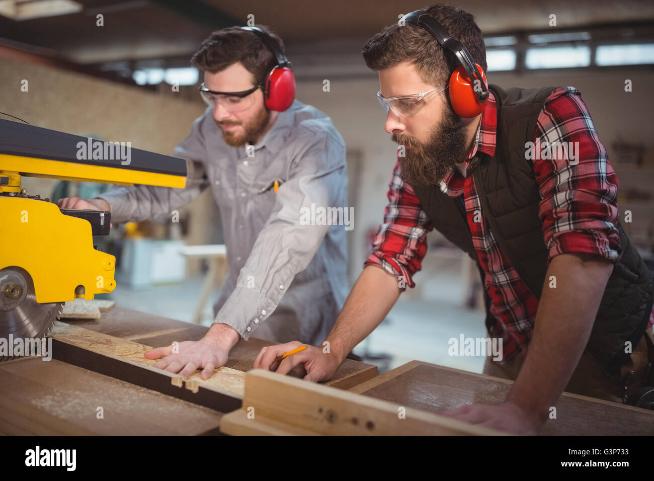 Carpenter using saw cutting machine Stock Photo - Alamy