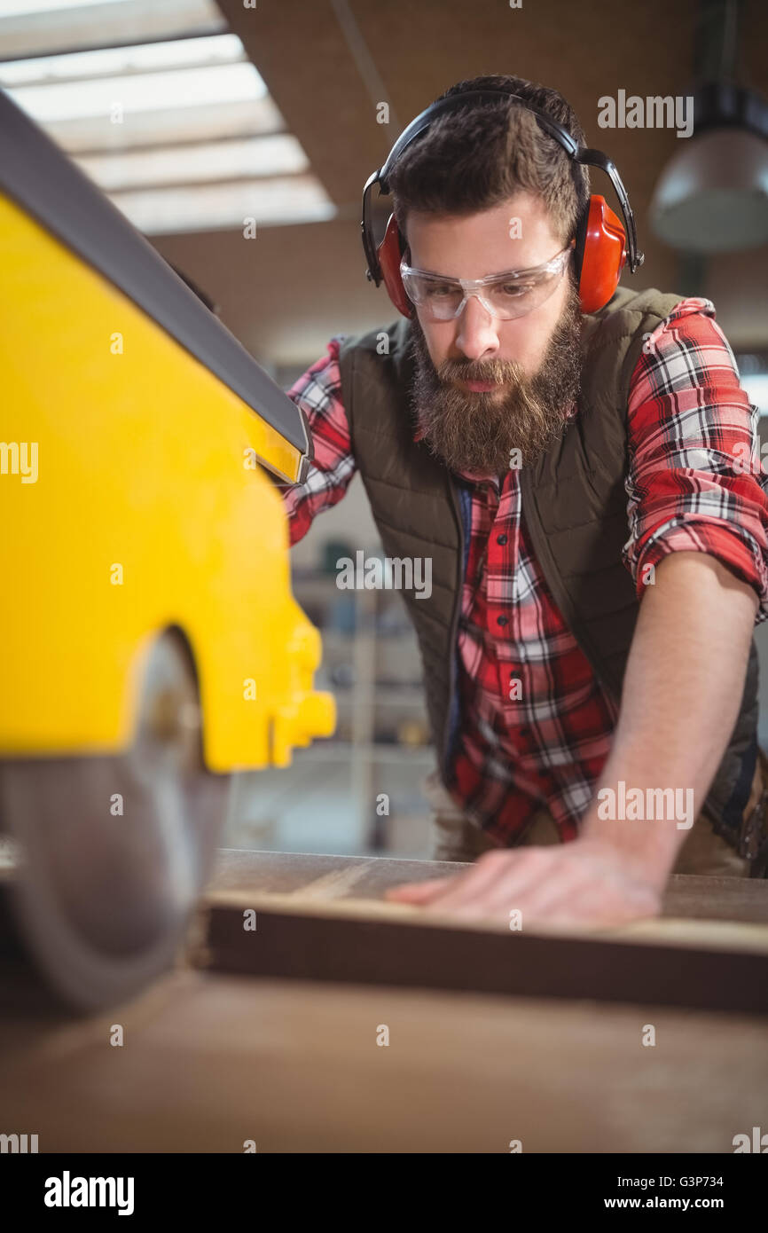 Carpenter using saw cutting machine Stock Photo - Alamy