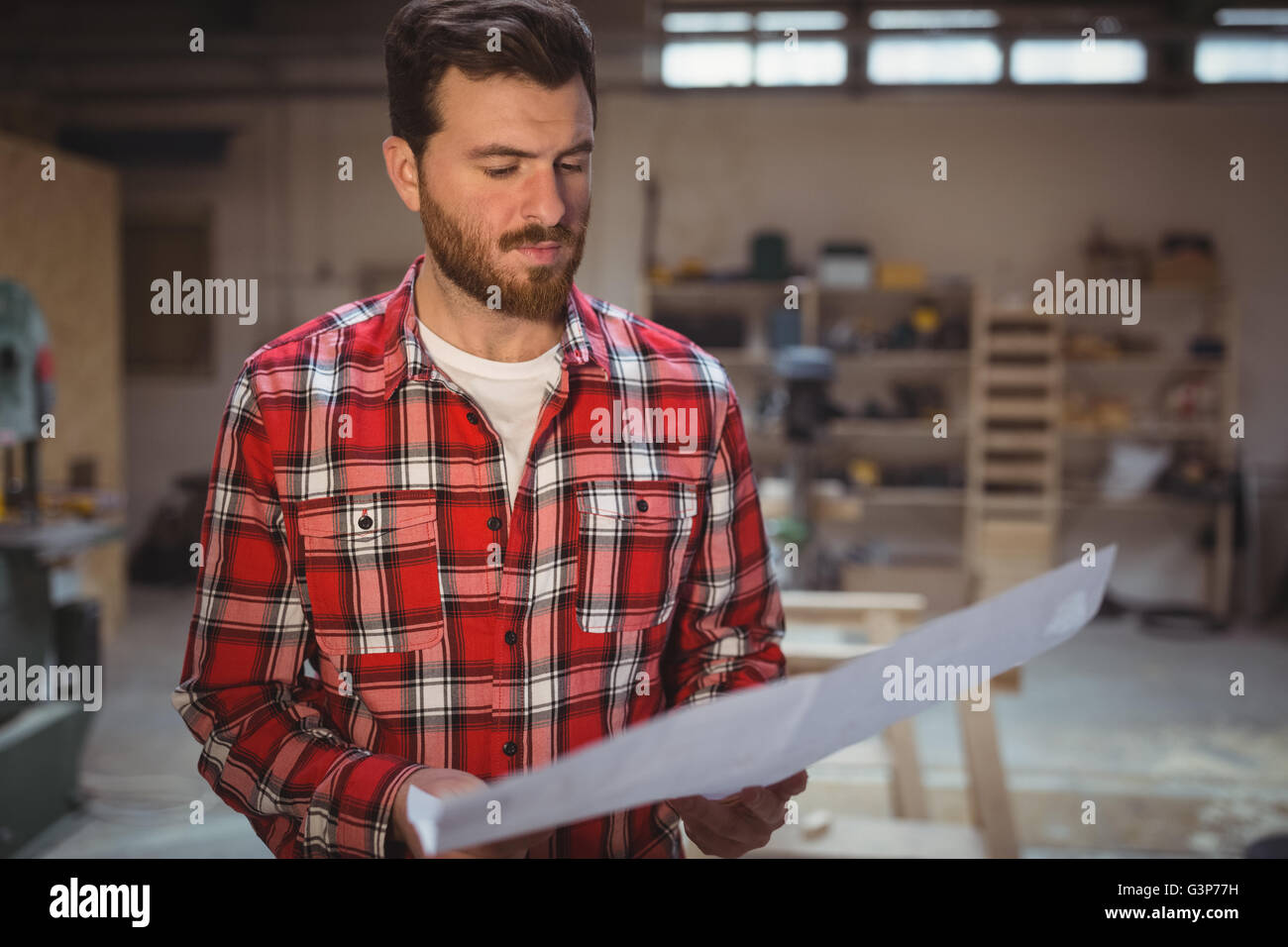 Carpenter looking at blueprint Stock Photo - Alamy