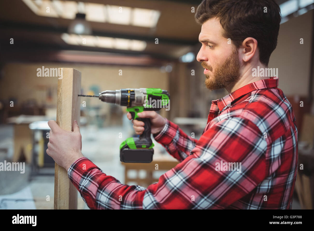 Carpenter drilling a hole in a wooden plank Stock Photo - Alamy