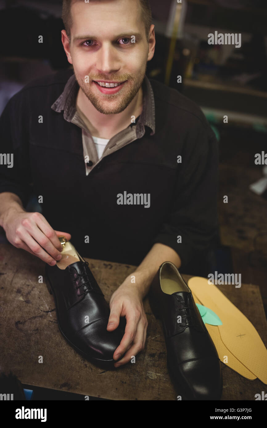 Cobbler placing shoe tree inside the shoes Stock Photo - Alamy