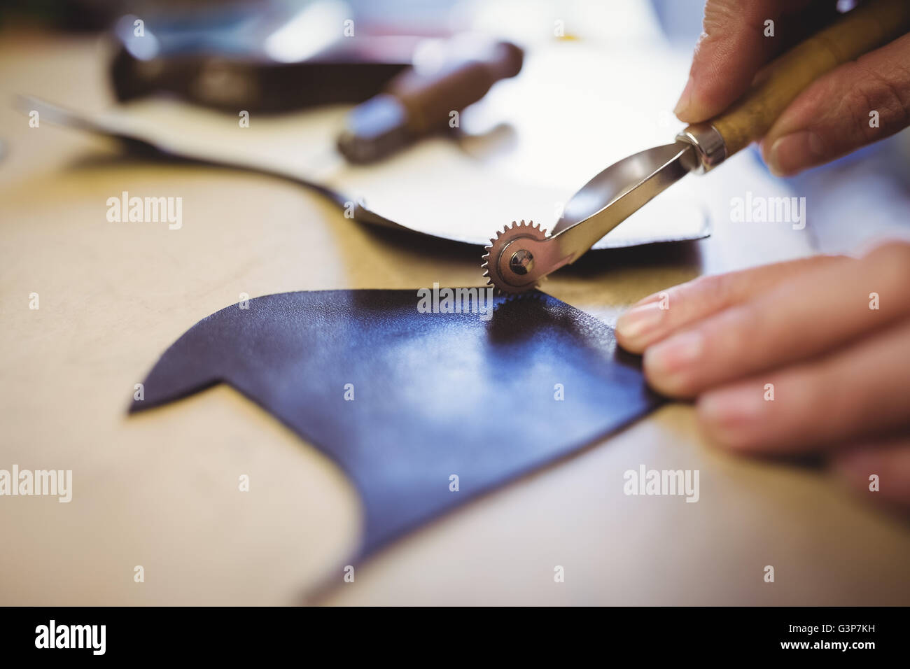 Cobbler using a tool on a material Stock Photo - Alamy