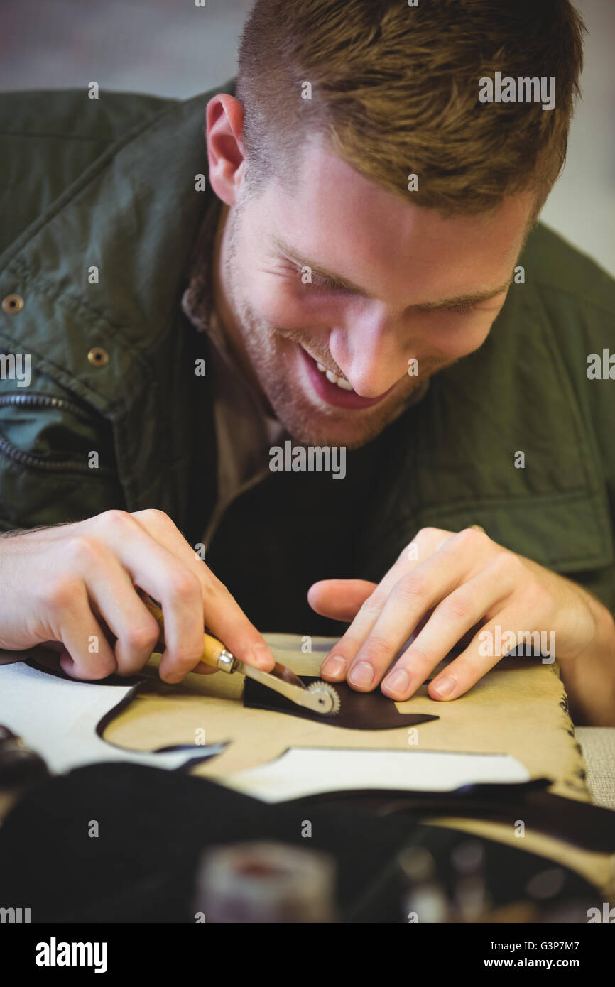 Cobbler using a tool on a piece of material Stock Photo - Alamy