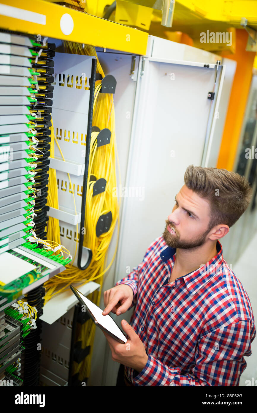 Technician using digital tablet while analyzing server Stock Photo - Alamy