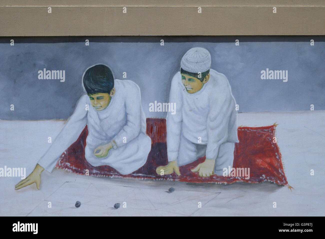 Arab wall art showing two boys playing a traditional game, Al Jasra ...