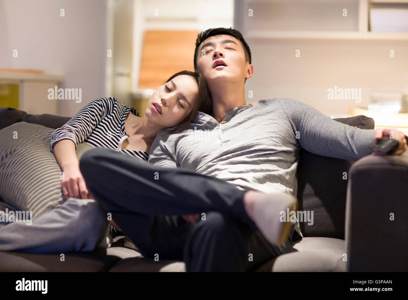 Tired couple sleeping on living room sofa Stock Photo - Alamy