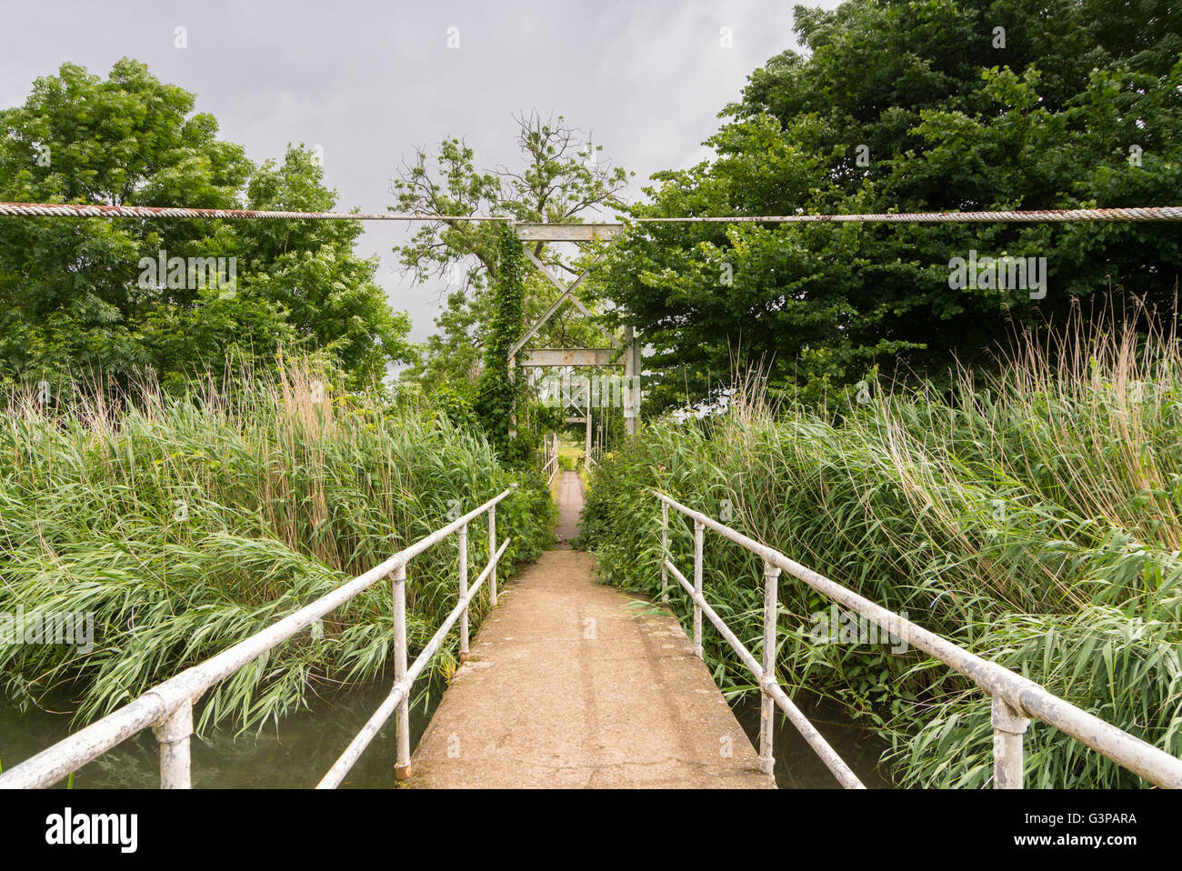 Small suspension bridge through lush green English countryside at near ...