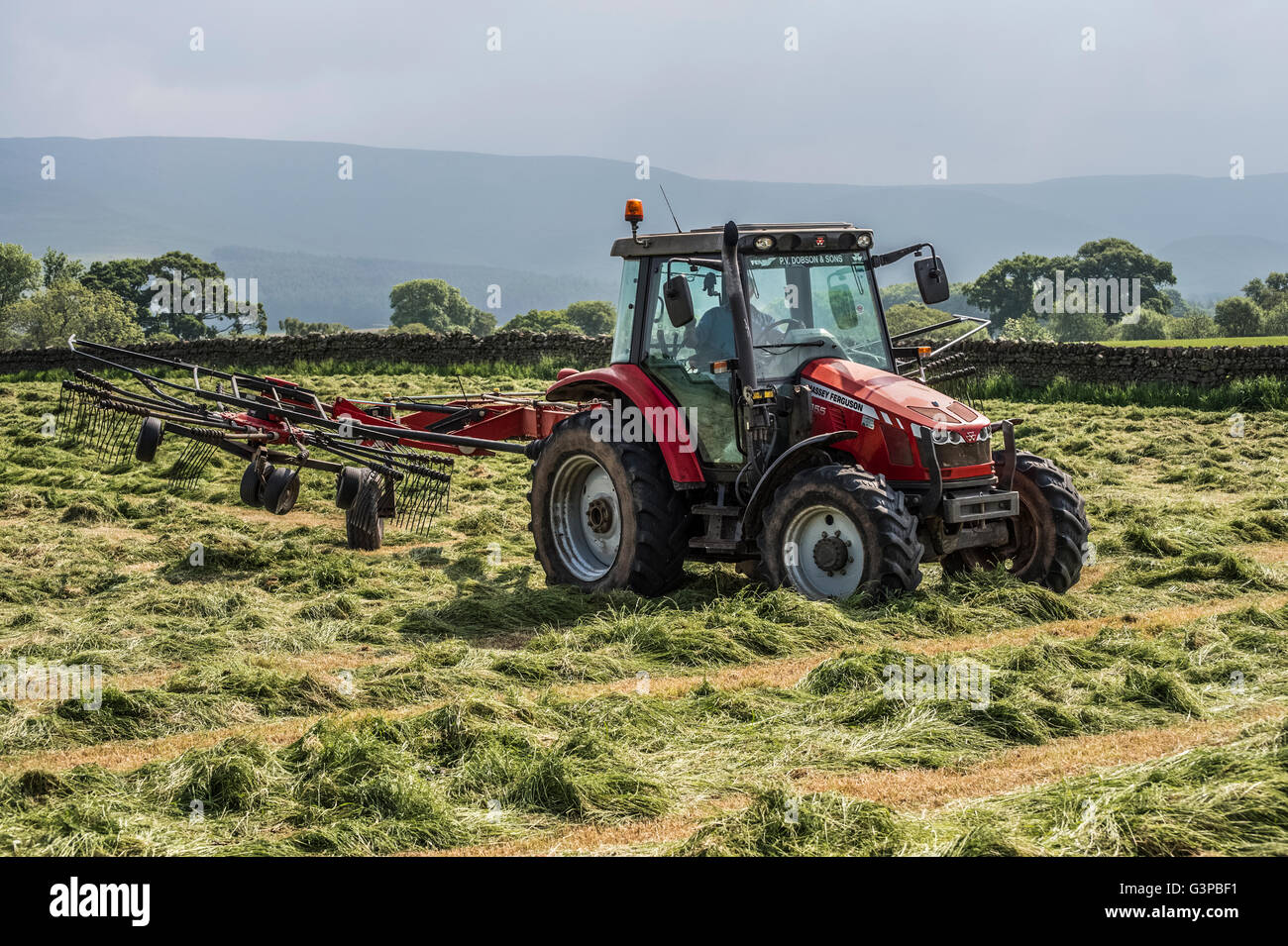 Farmers at work cutting grass and hay-making Stock Photo - Alamy