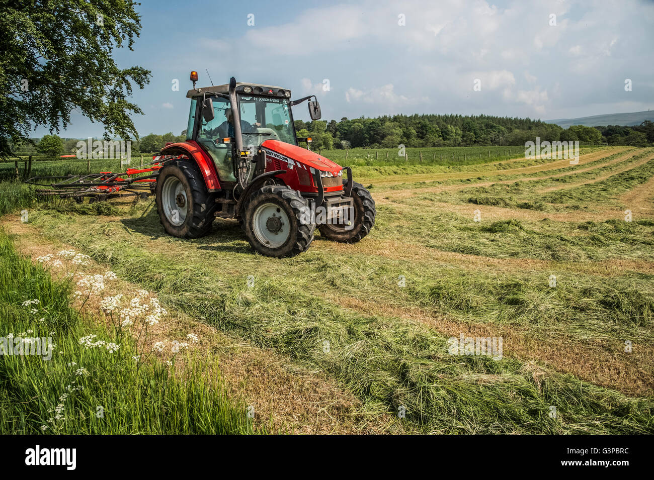 Farmers at work cutting grass and hay-making Stock Photo - Alamy