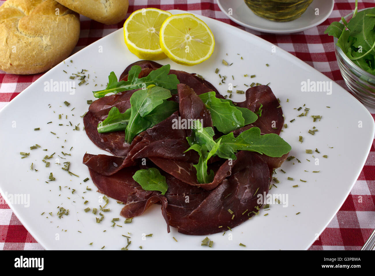 Slices of air-dried beef, called as bresaola, with rucola salad, olive ...