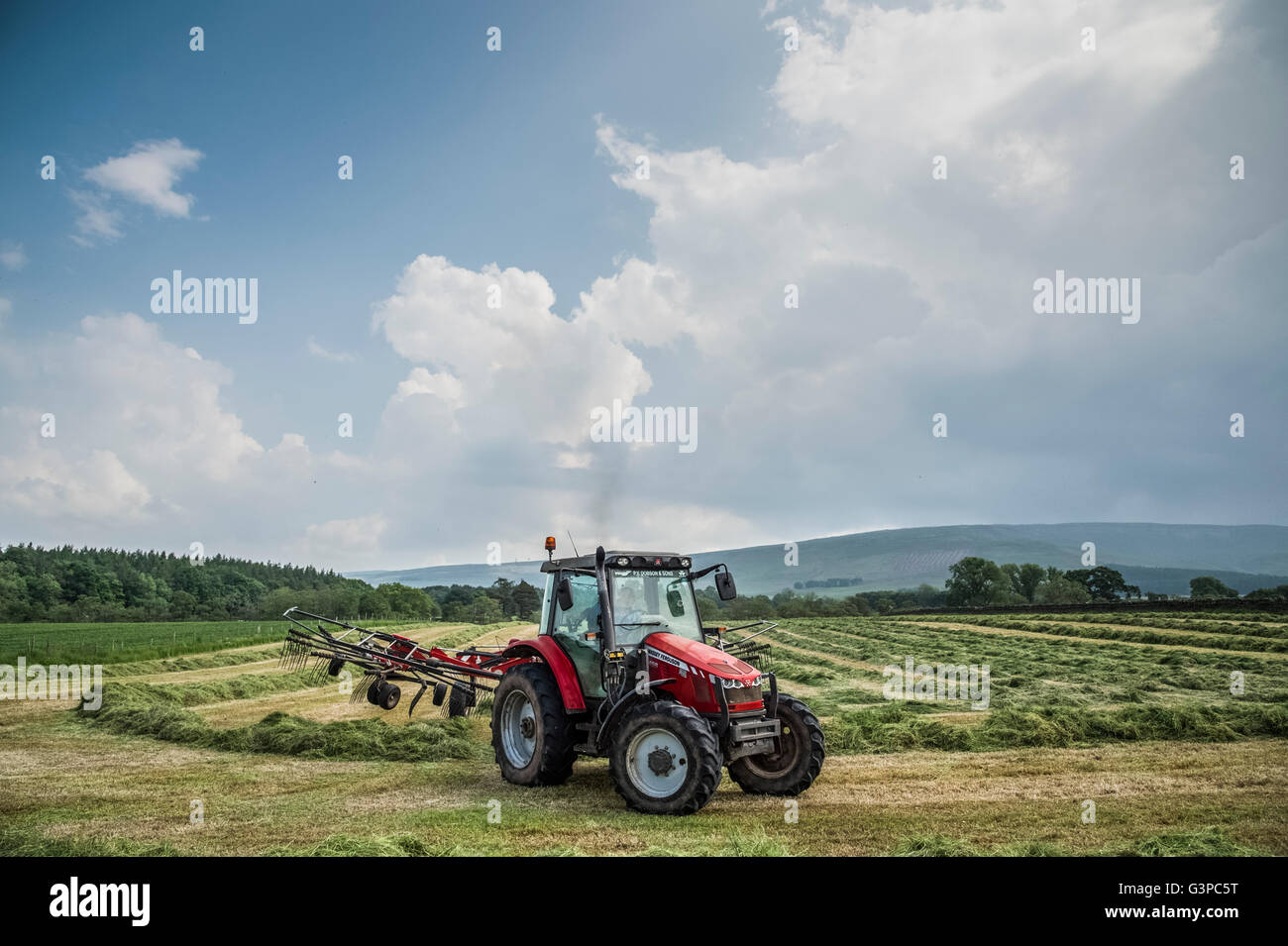 Farmers at work cutting grass and hay-making Stock Photo - Alamy