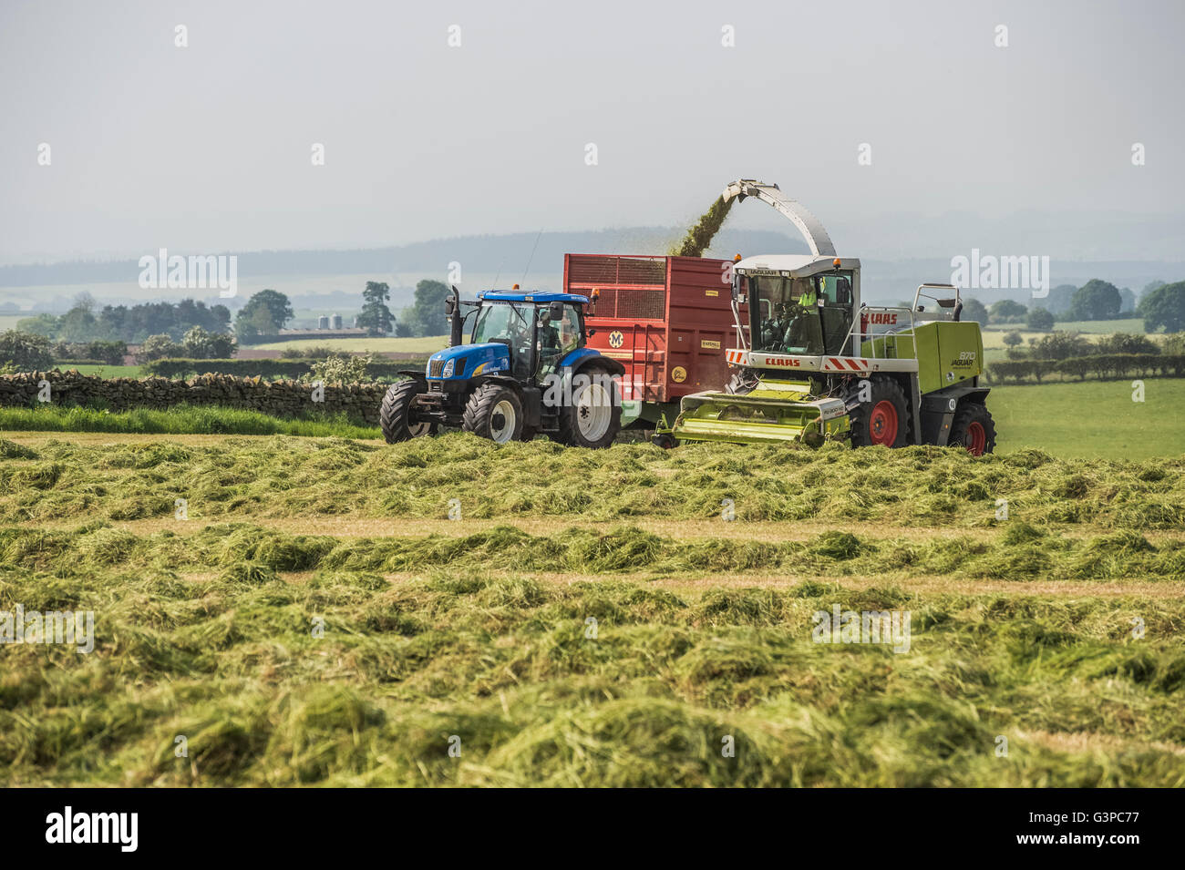 Farmers at work cutting grass and hay-making Stock Photo - Alamy