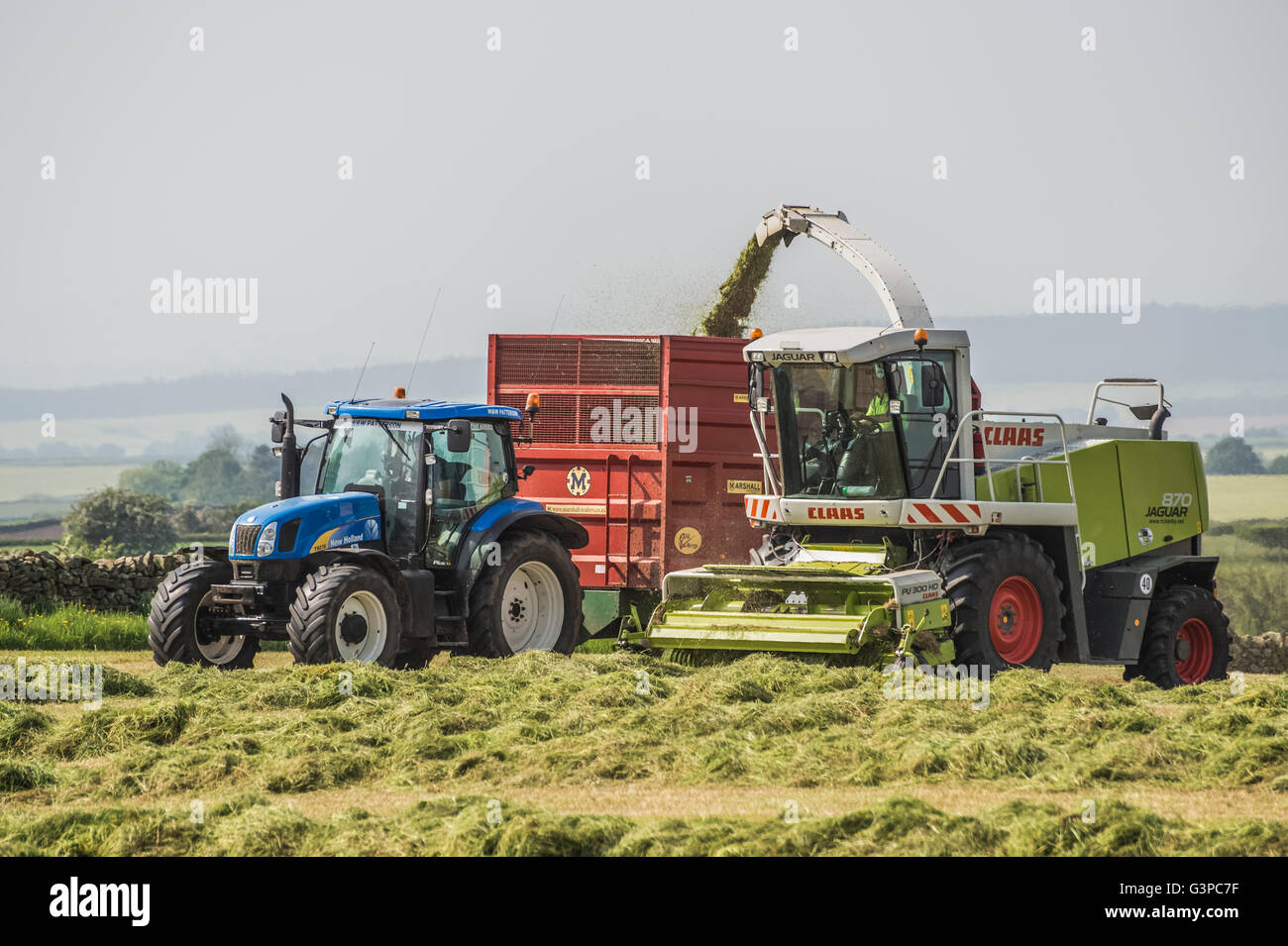 Farmers at work cutting grass and hay-making Stock Photo - Alamy