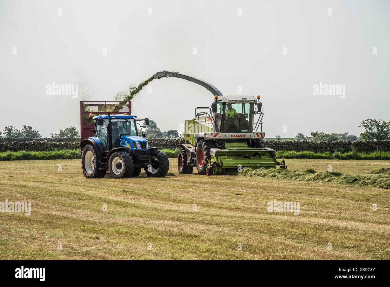 Farmers at work cutting grass and hay-making Stock Photo - Alamy