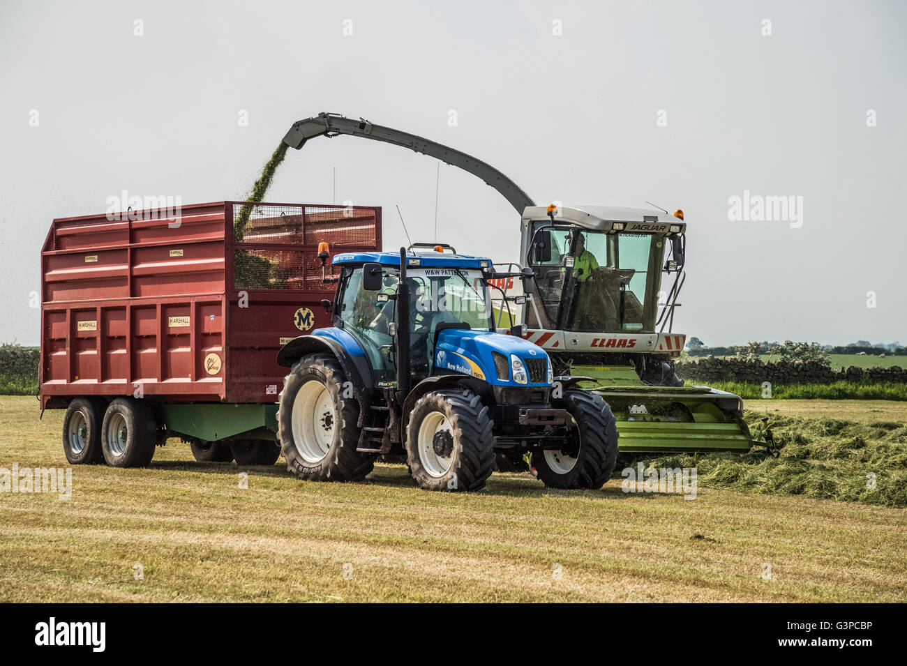 Farmers at work cutting grass and hay-making Stock Photo - Alamy