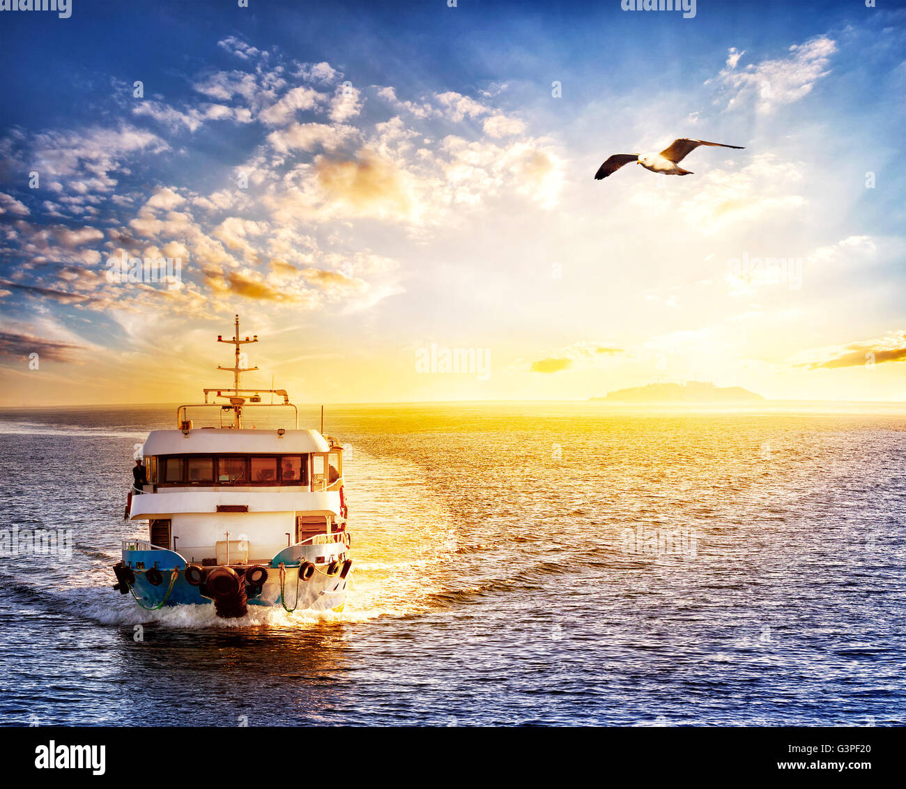 Ship at sea with an island on sunset Stock Photo - Alamy