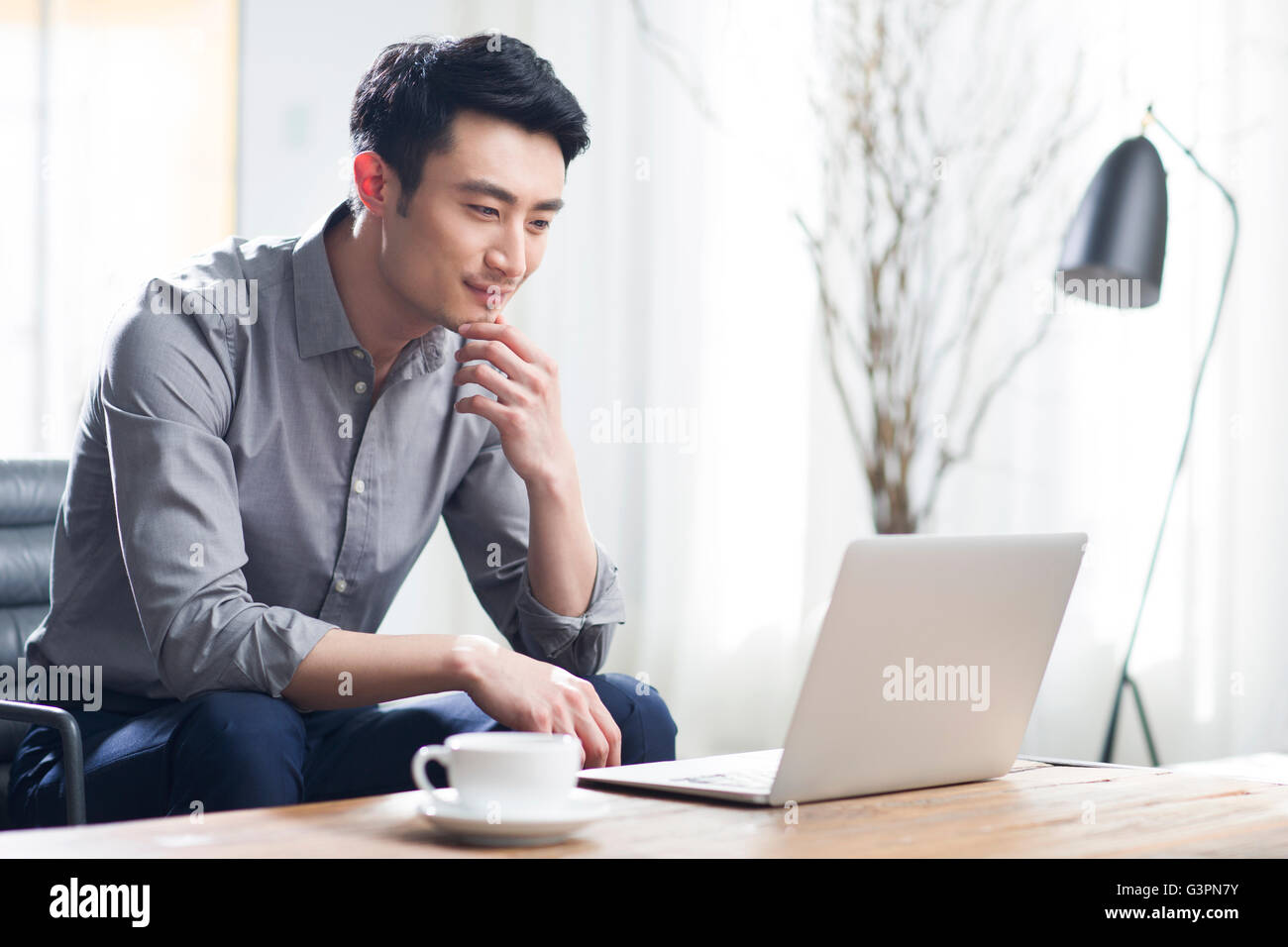 Young man working with laptop in office Stock Photo - Alamy