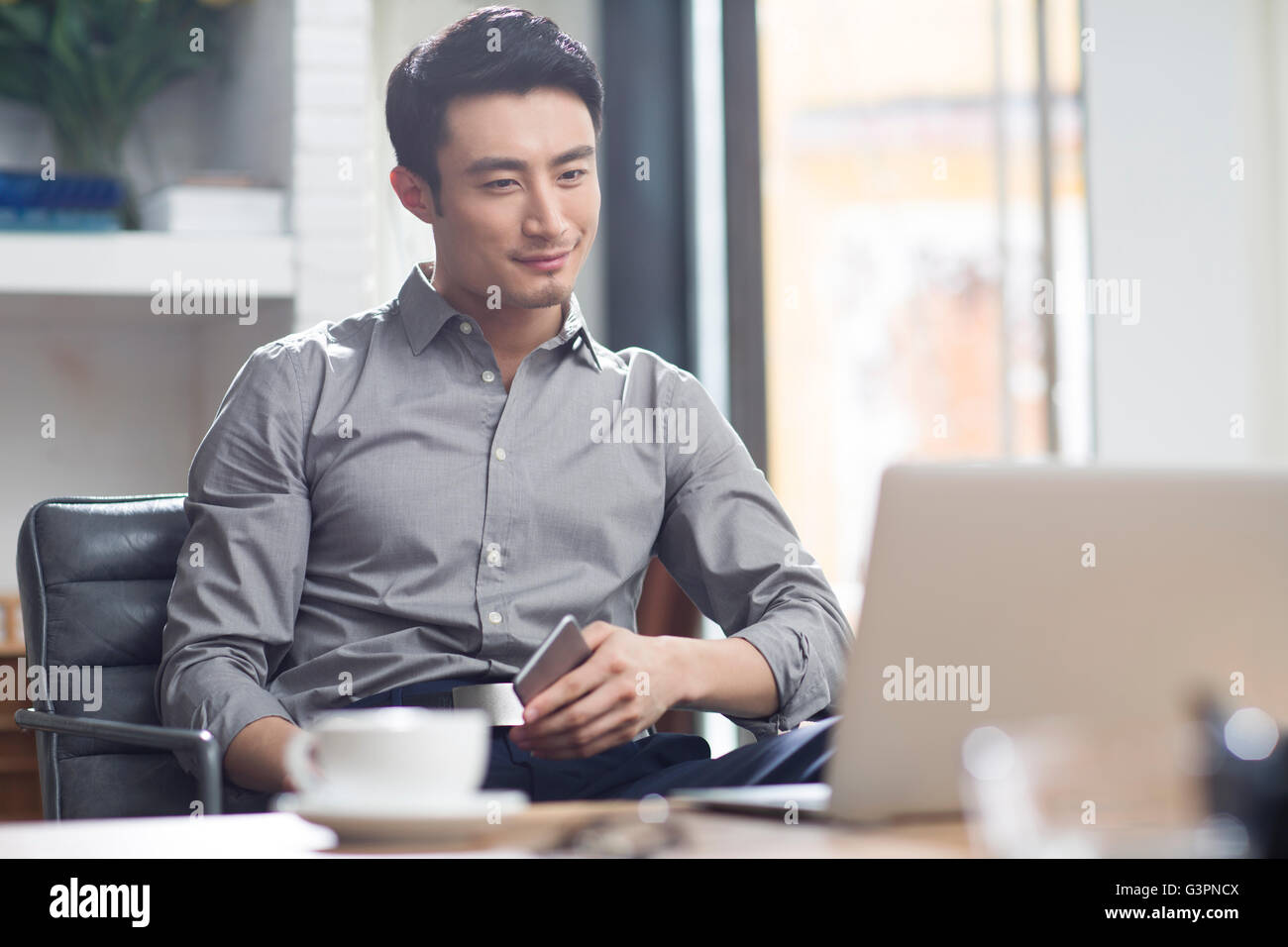 Young man working with laptop in office Stock Photo - Alamy