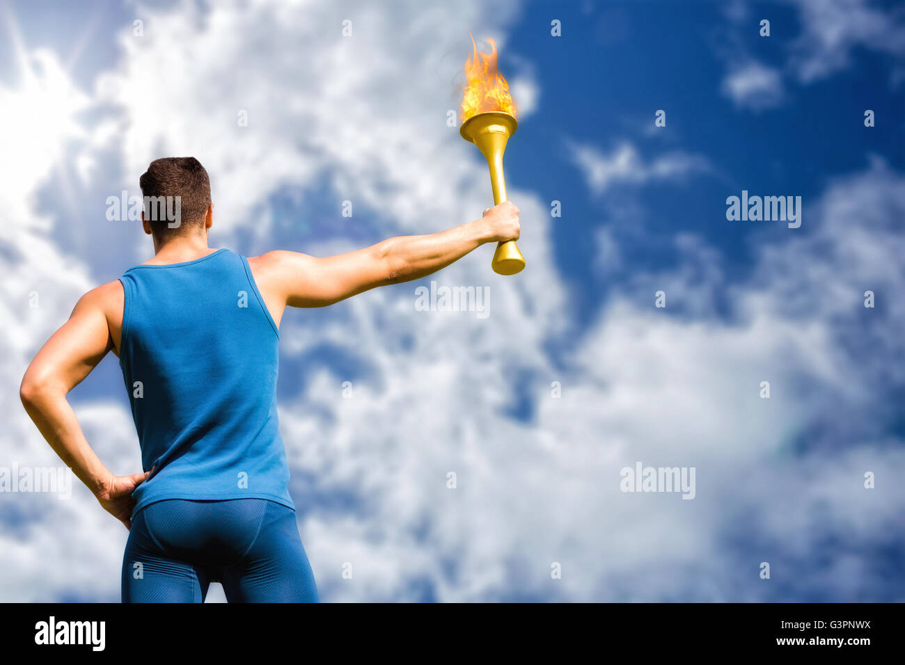 Composite image of rear view of athletic man holding the olympic torch ...