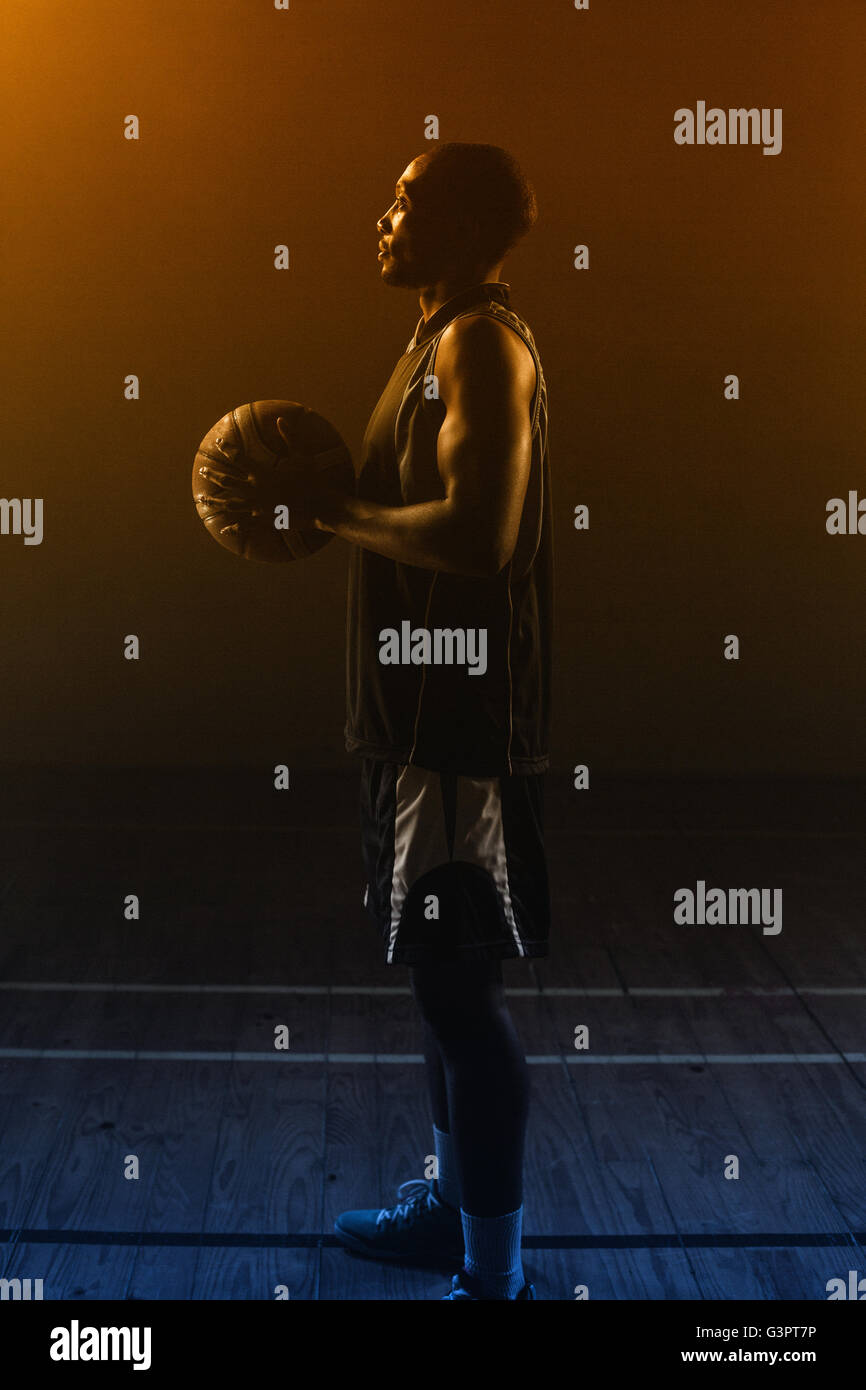 Side view of a basketball player holding a basketball Stock Photo - Alamy