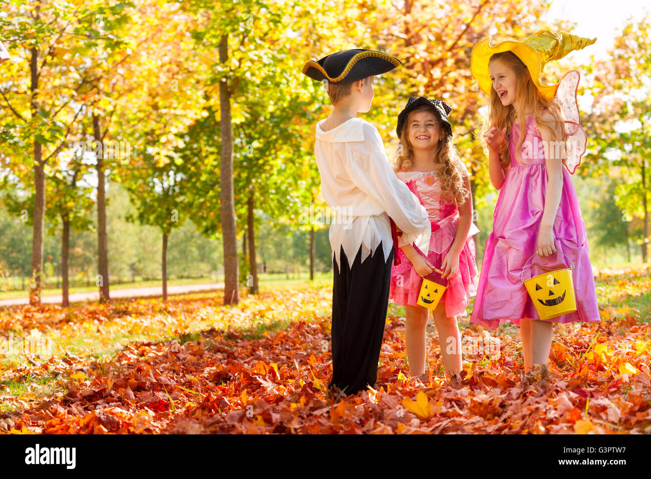 Positive children in Halloween costumes talking Stock Photo - Alamy