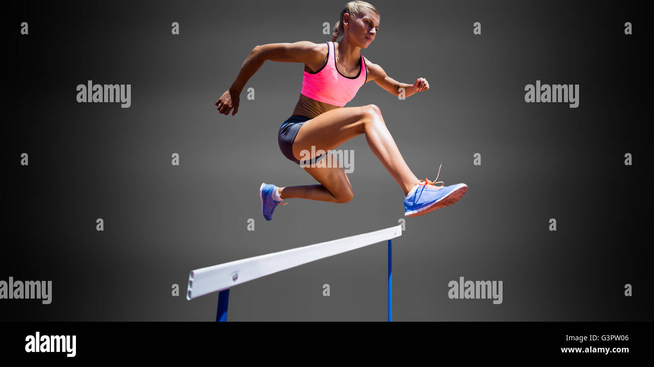 Sporty woman jumping a hurdle Stock Photo - Alamy