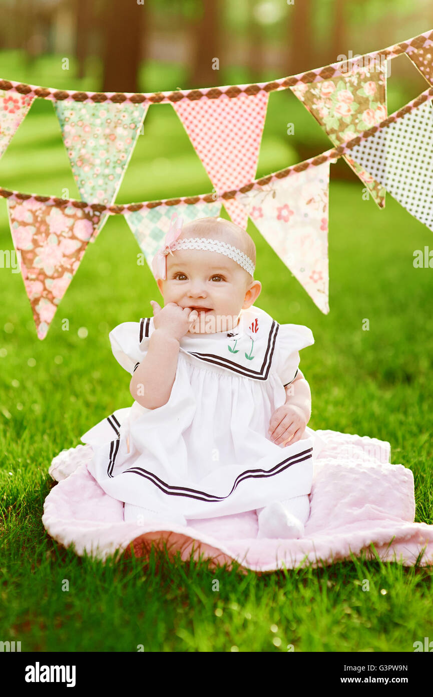 happy little girl sitting on grass with flags Stock Photo - Alamy