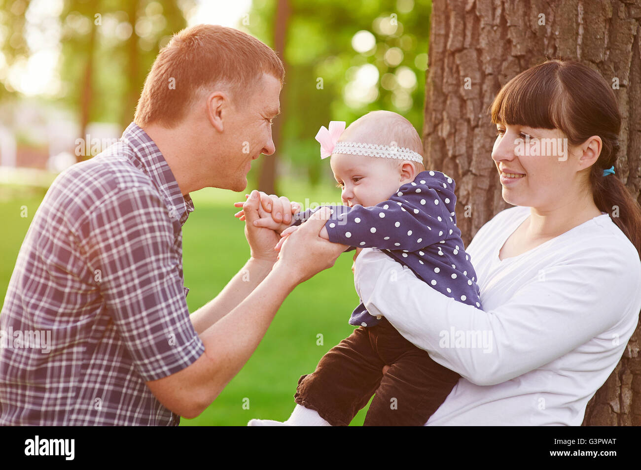 family parenthood concept - happy mother father and little girl playing ...
