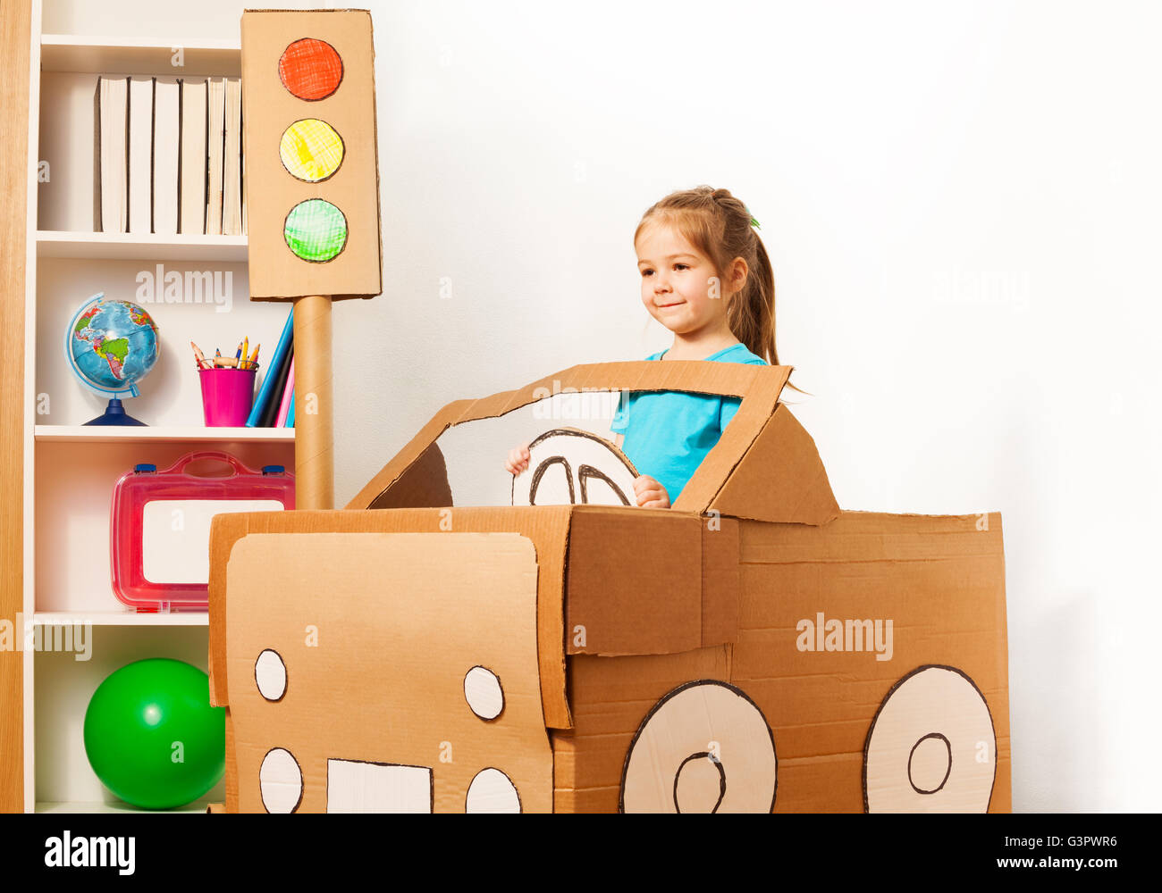 Cute little girl driving her toy cardboard car Stock Photo - Alamy