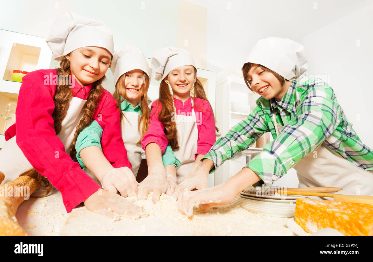 Four friends kneading bakery dough at the kitchen Stock Photo - Alamy