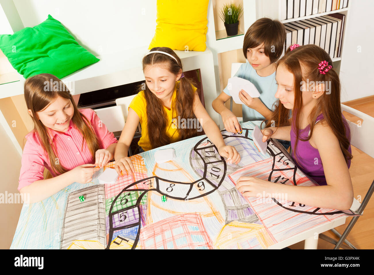 Top view of four kids playing the tabletop game Stock Photo - Alamy