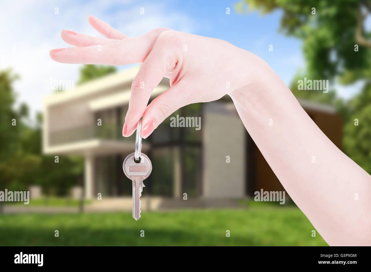 Female hand hanging house key as real estate concept with residential ...