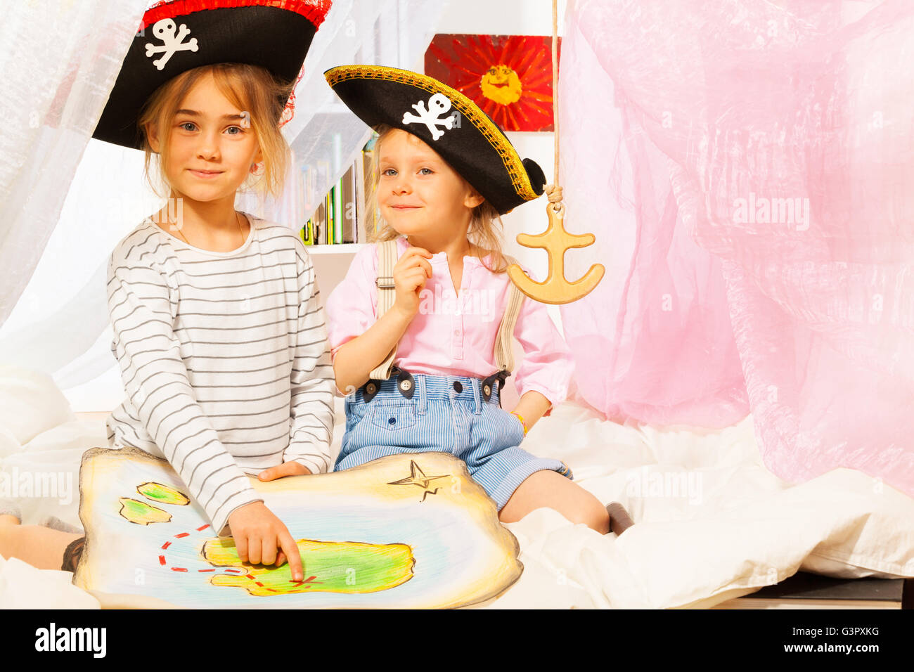 Two little girls playing pirates with treasure map Stock Photo - Alamy