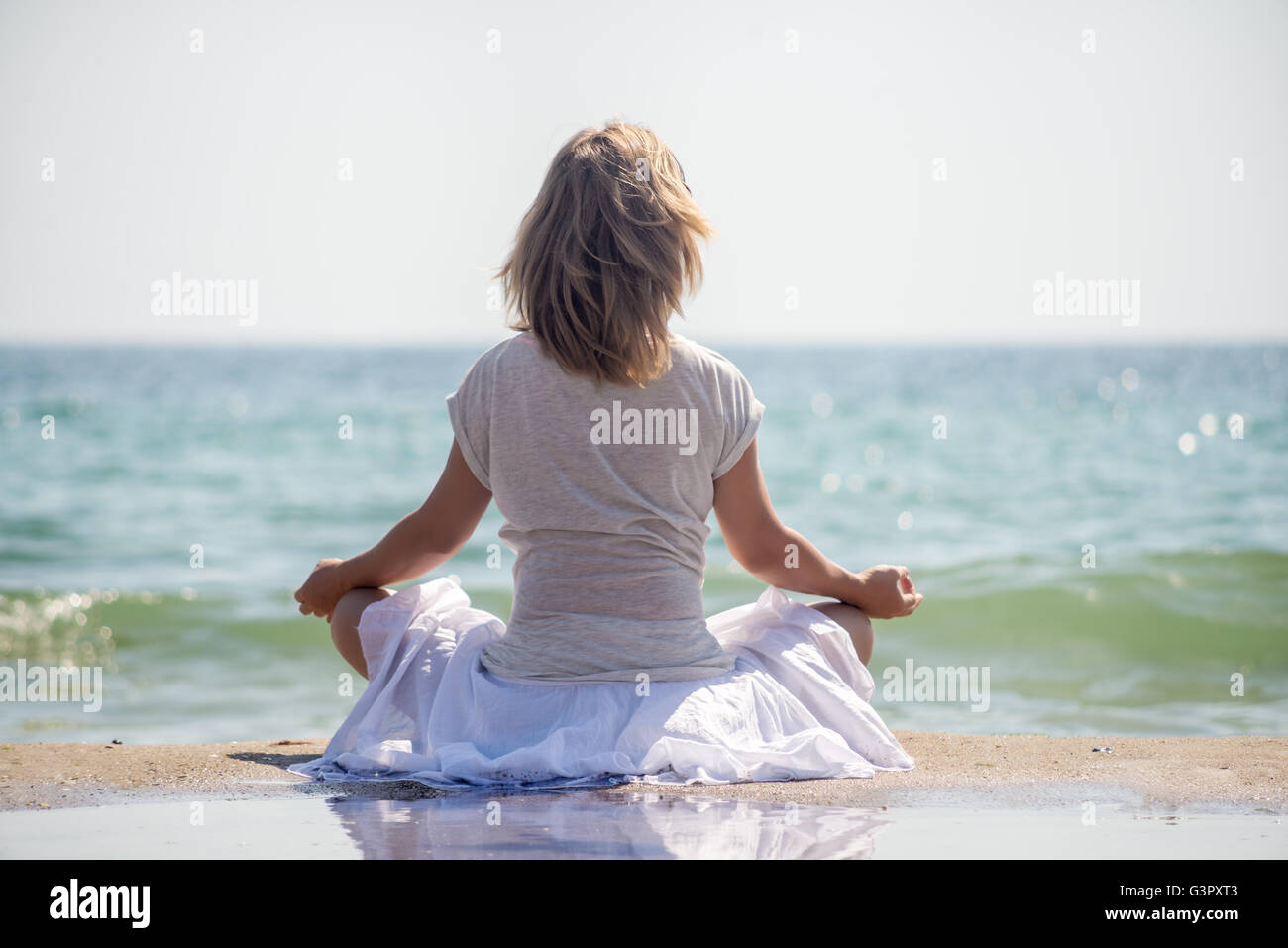 Woman meditating at the sea Stock Photo - Alamy
