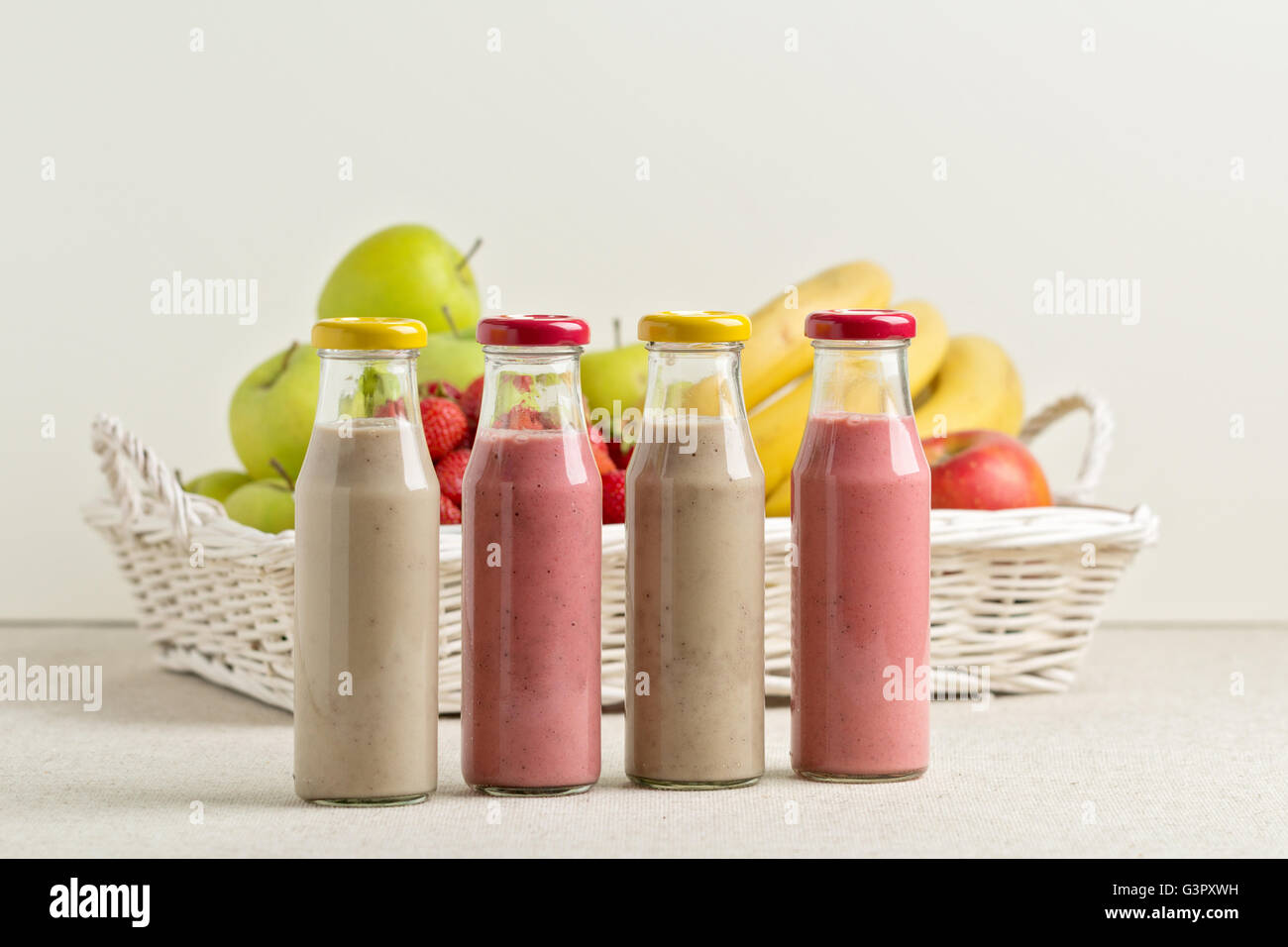 Fruit basket and strawberry and banana smoothie in a glass bottle ...